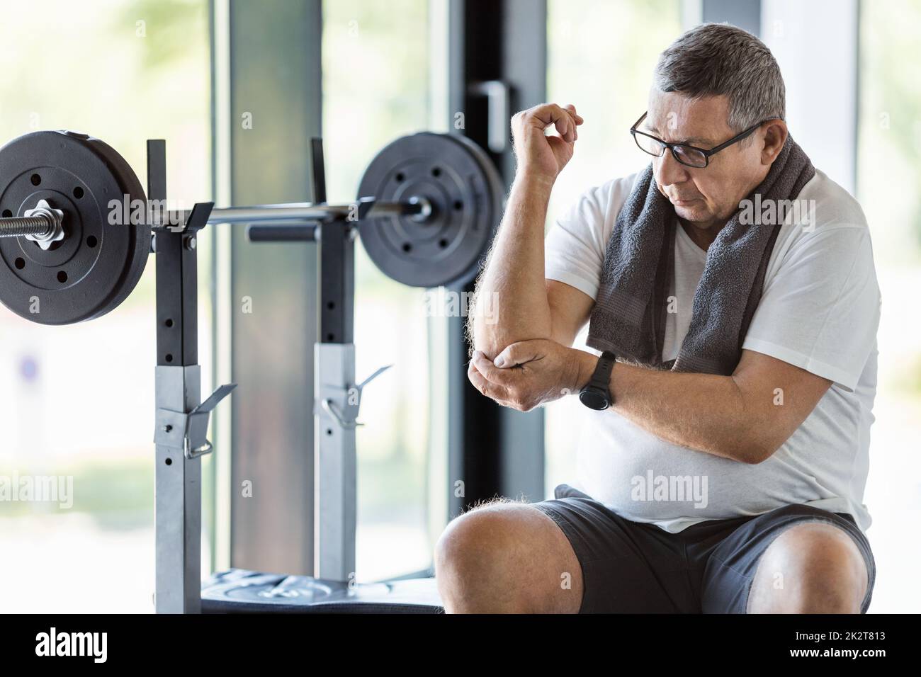 Active senior in a gym with elbow pain Stock Photo - Alamy