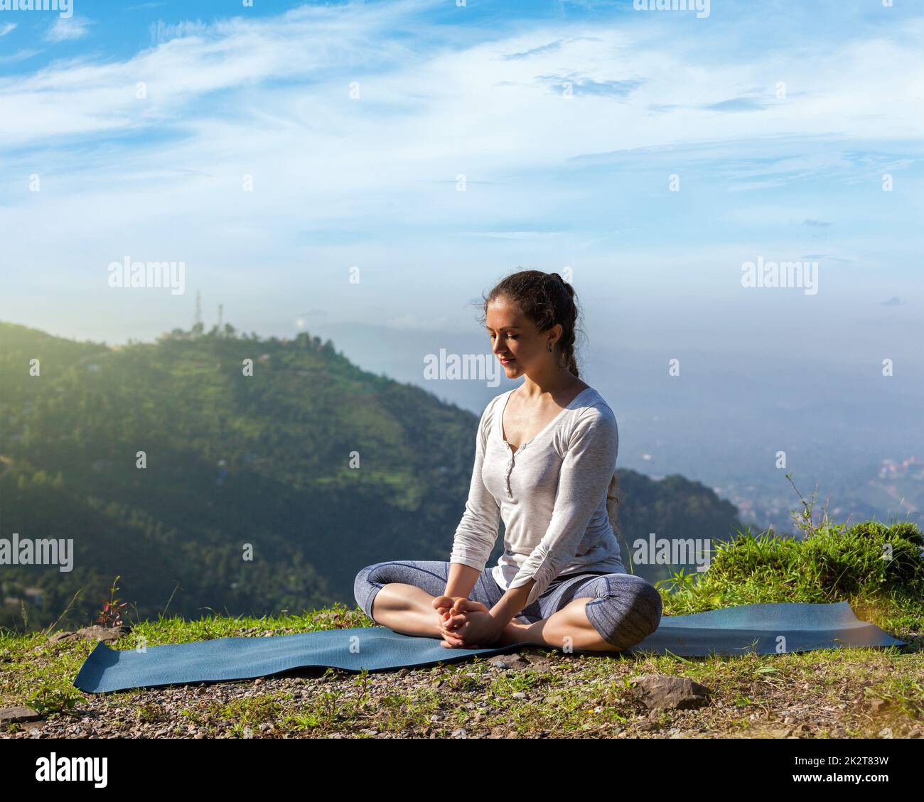 Woman practice yoga asana Baddha Konasana outdoors Stock Photo - Alamy