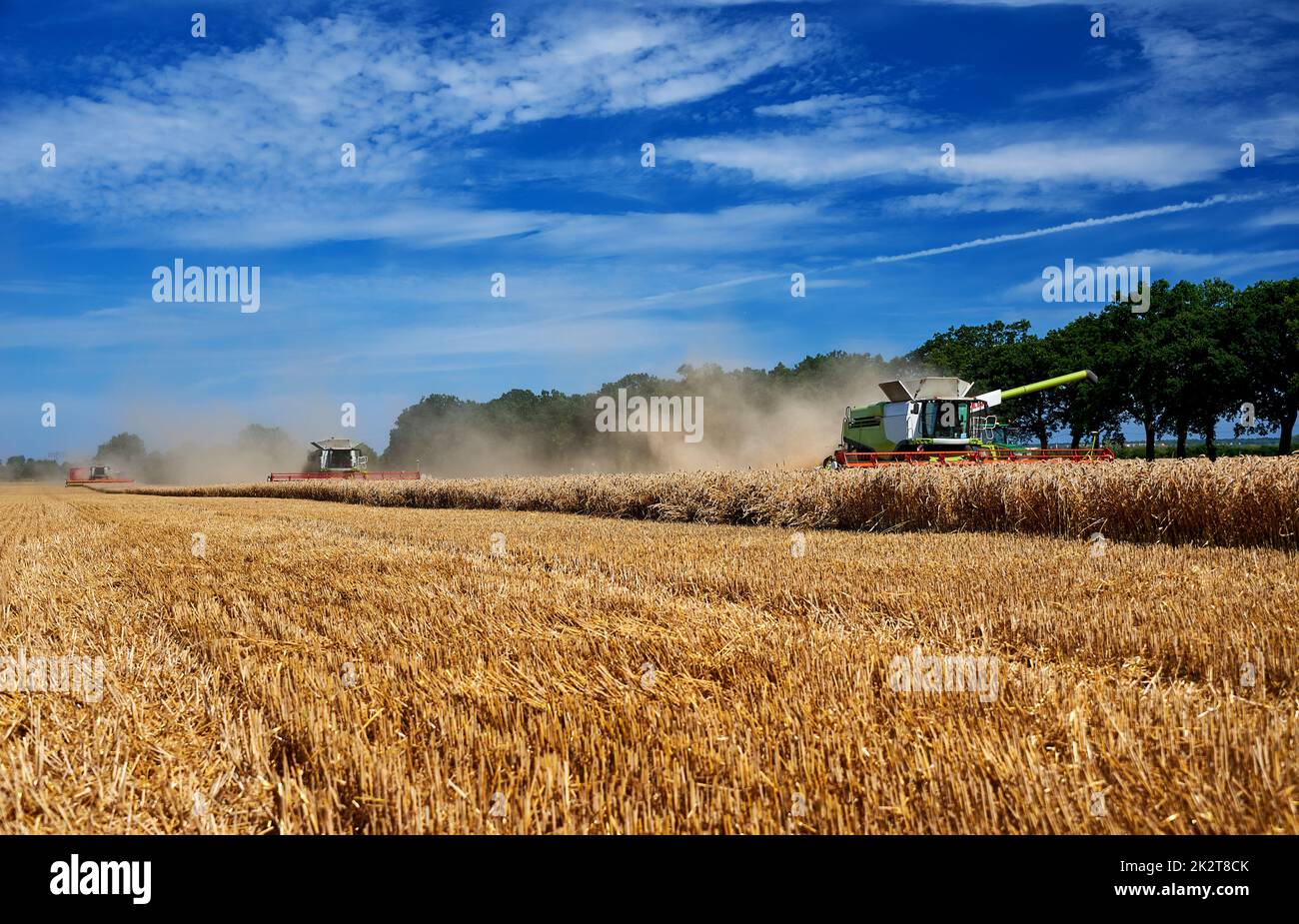 wheat harvester machine at work on field Stock Photo - Alamy