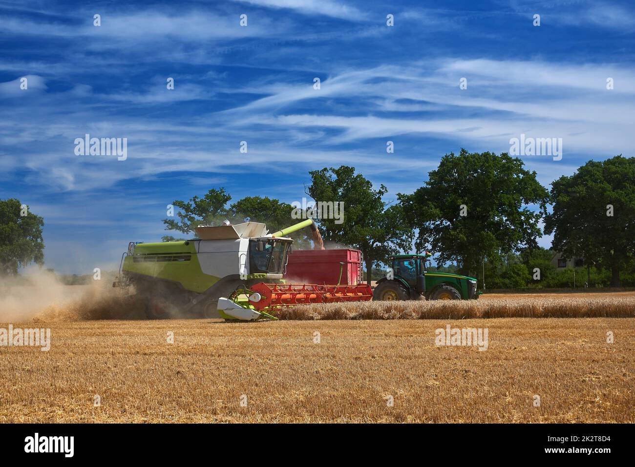 wheat harvester machine at work on field Stock Photo - Alamy