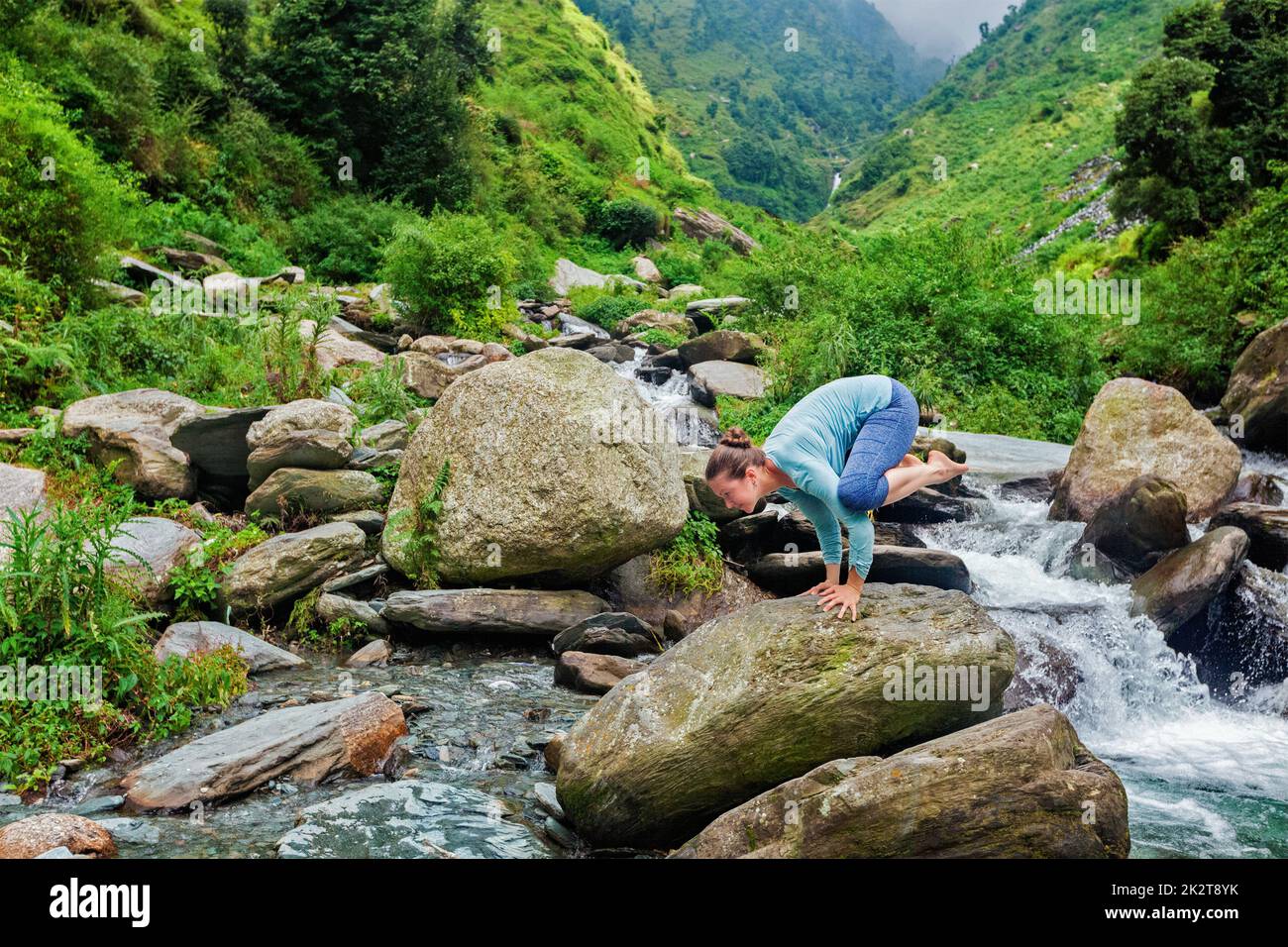 Woman doing Kakasana asana arm balance outdoors Stock Photo - Alamy