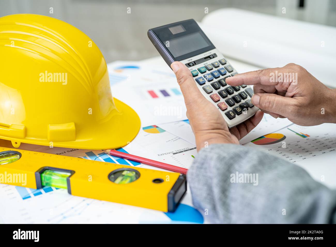 Asian engineer with architectural house plan project blueprint, graph ...