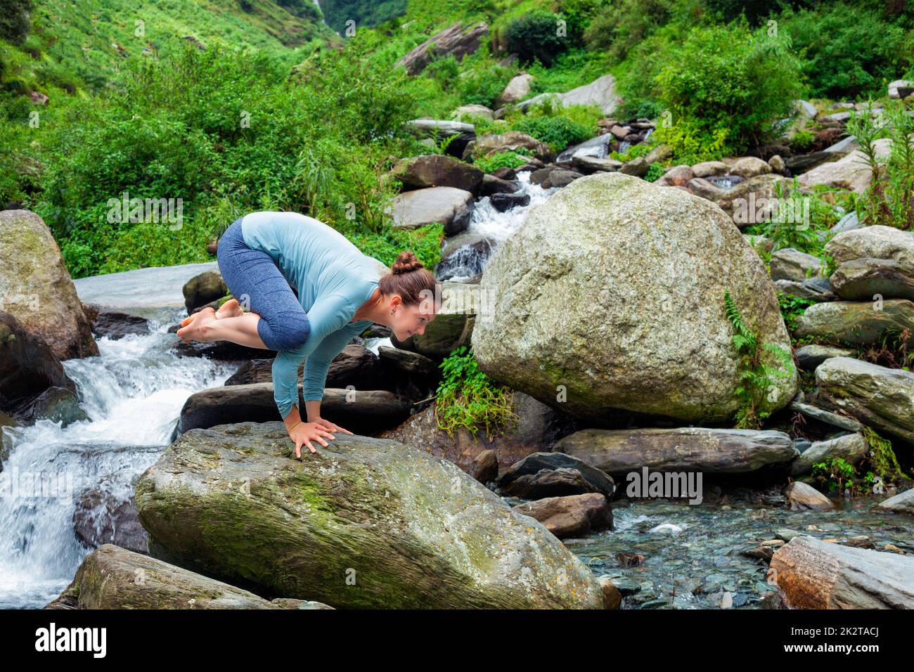 Woman doing Kakasana asana arm balance outdoors Stock Photo - Alamy