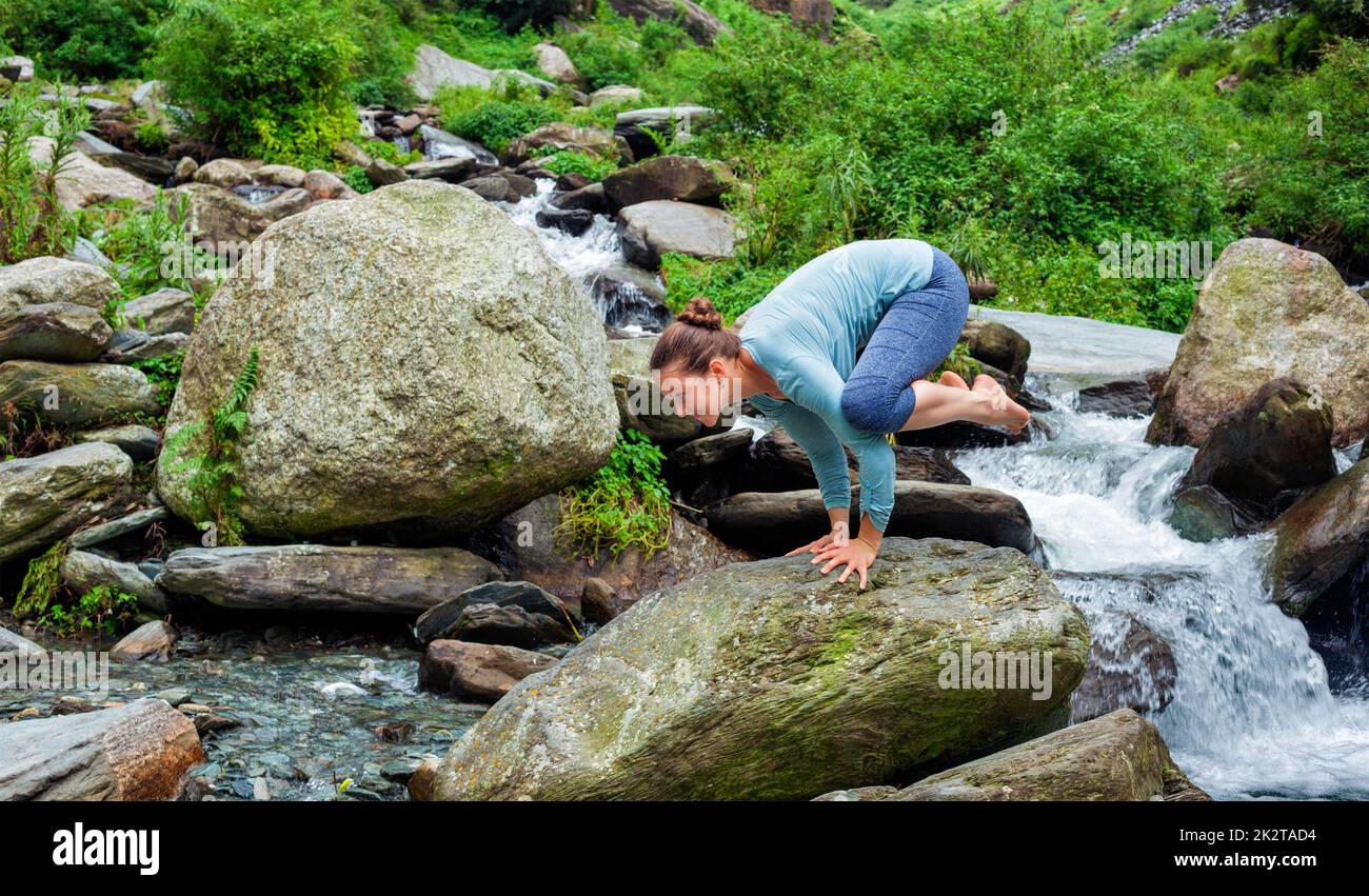Woman doing Kakasana asana arm balance outdoors Stock Photo - Alamy