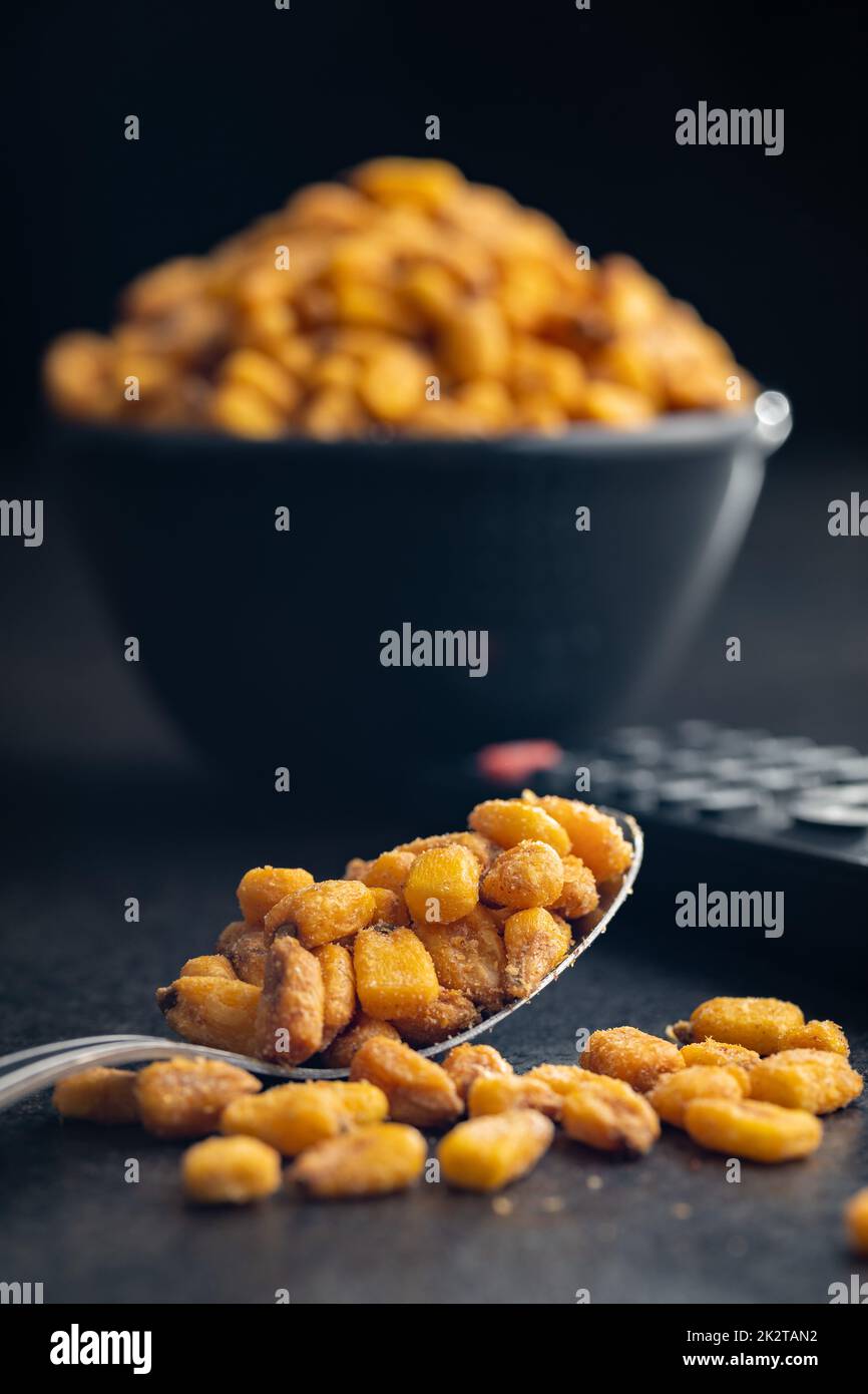 Roasted salted corn snack in spoon on black table Stock Photo - Alamy
