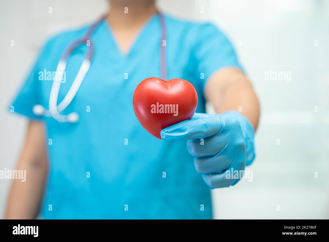 Doctor holding a red heart in hospital ward, healthy strong medical ...