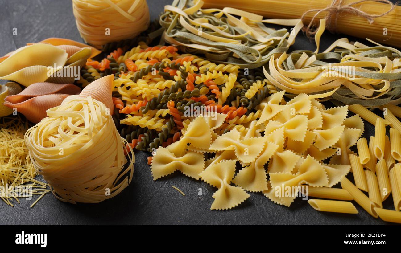 Assortment of raw pasta. Different kinds of macaroni, tagliatelle ...