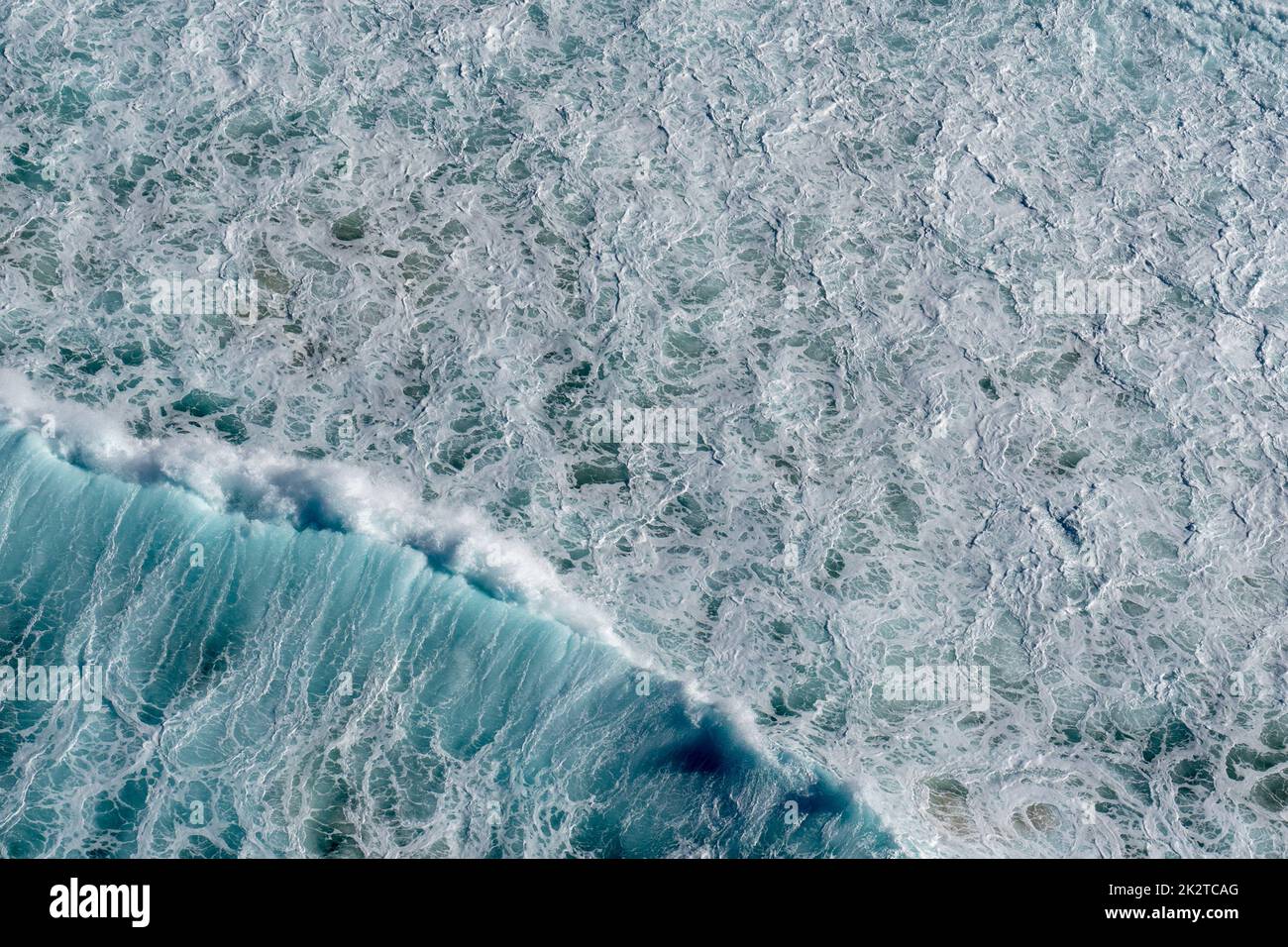 A beautiful view of a blue seascape with surfers catching waves in ...