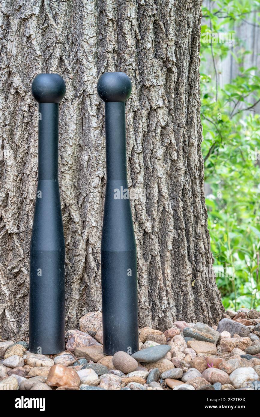 pair of heavy steel clubs in backyard Stock Photo - Alamy