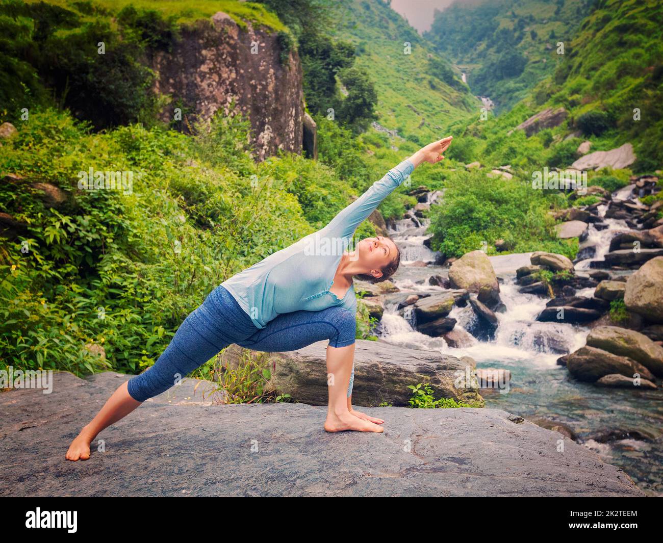 Woman practices yoga asana Utthita Parsvakonasana outdoors Stock Photo ...