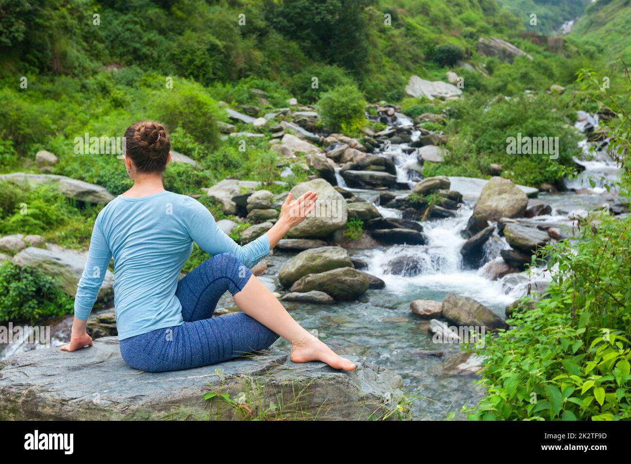 Woman doing Ardha matsyendrasanaasana asana outdoors Stock Photo - Alamy