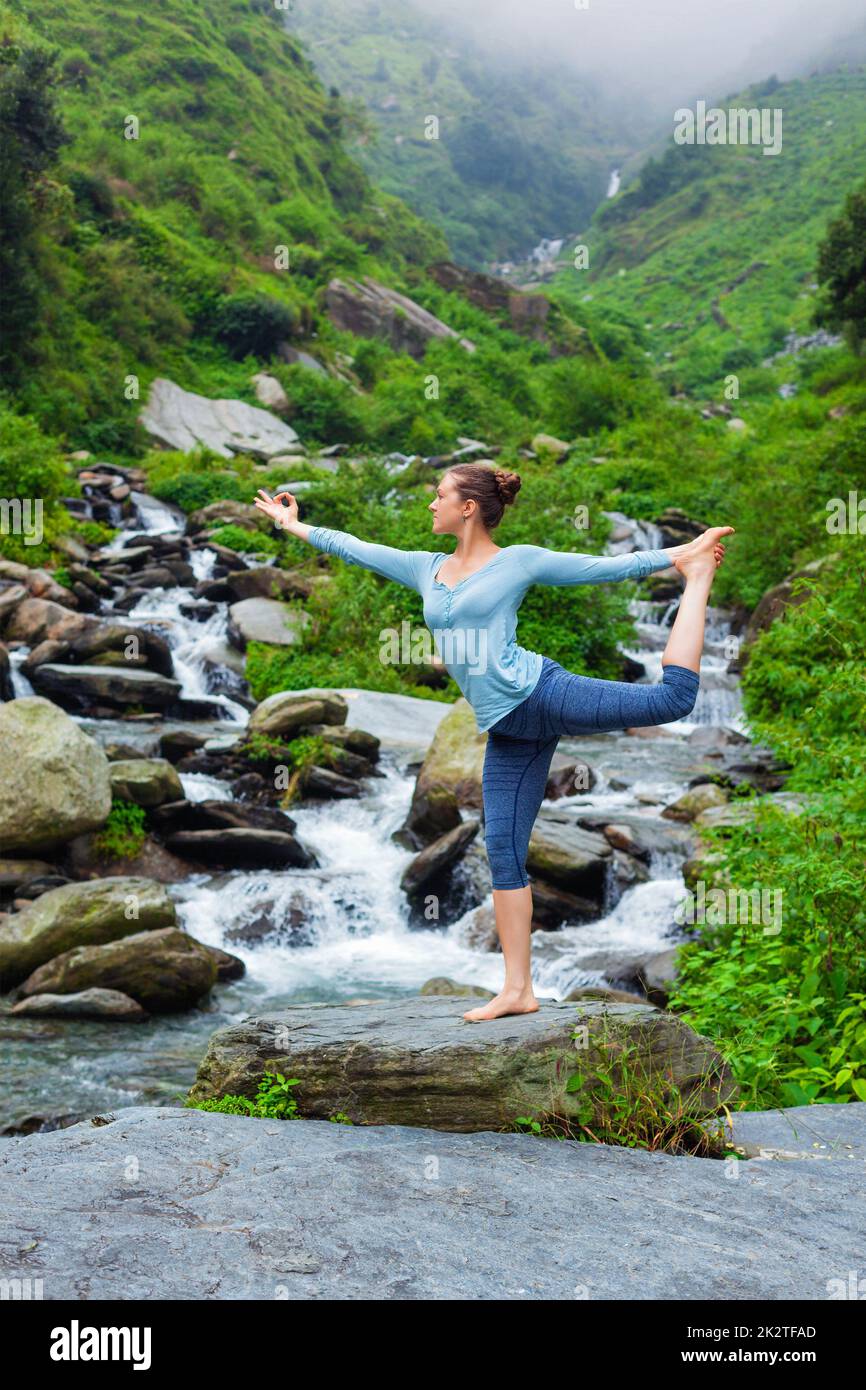 Woman doing yoga asana Natarajasana outdoors at waterfall Stock Photo ...
