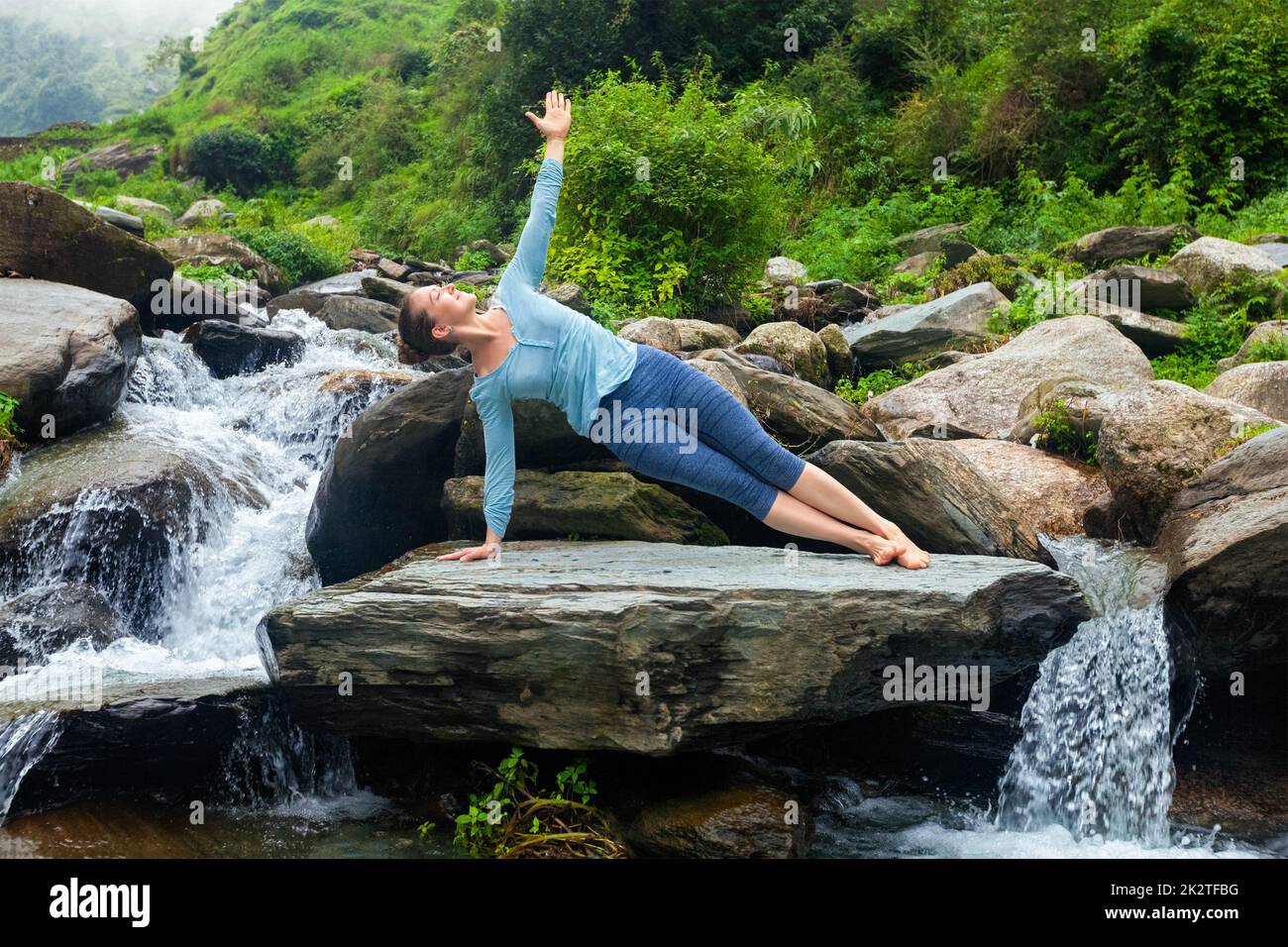 Woman doing yoga asana Vasisthasana - side plank pose outdoors Stock ...