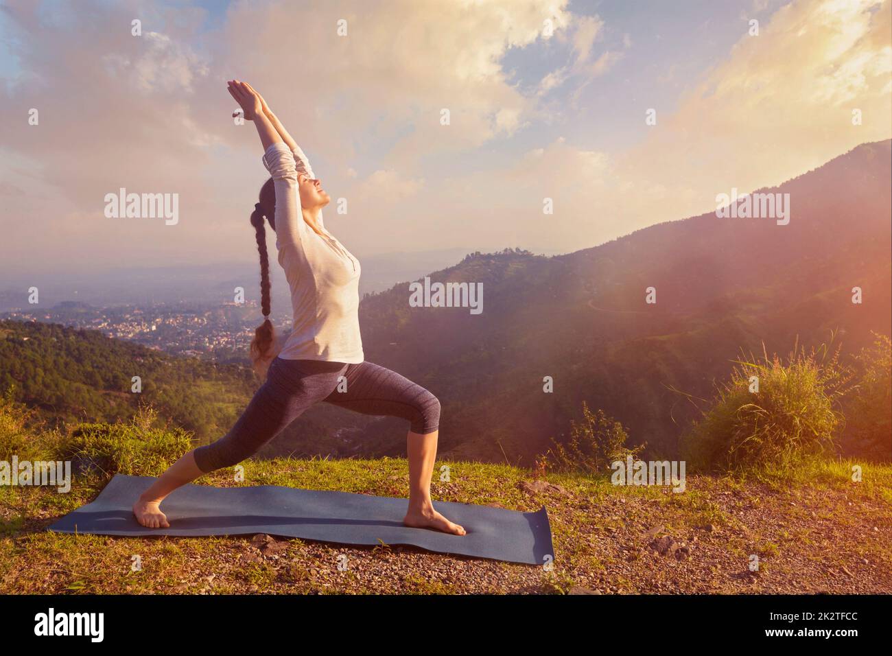 Woman doing yoga asana Virabhadrasana 1 - Warrior pose outdoors Stock ...