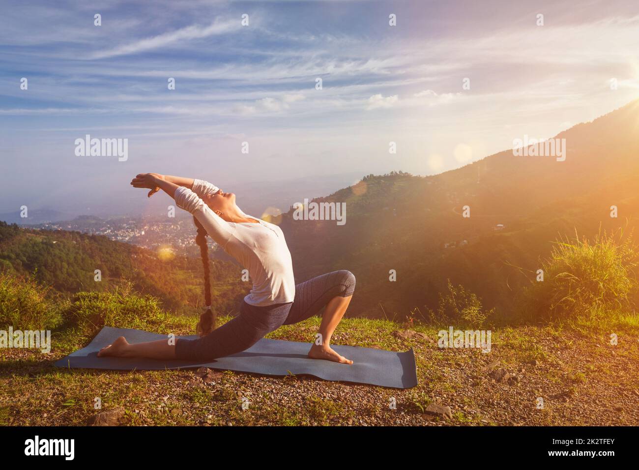 Sporty fit woman practices yoga Anjaneyasana in mountains Stock Photo ...