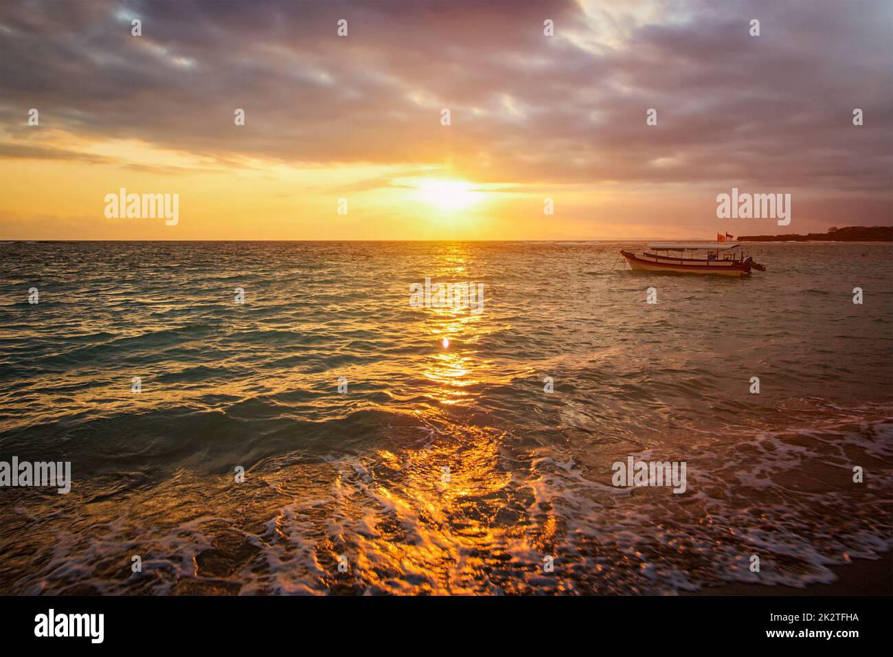 Calm ocean with boat on sunrise Stock Photo - Alamy