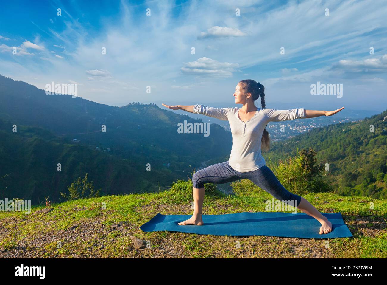 Woman doing yoga asana Virabhadrasana 2 - Warrior pose outdoors Stock ...