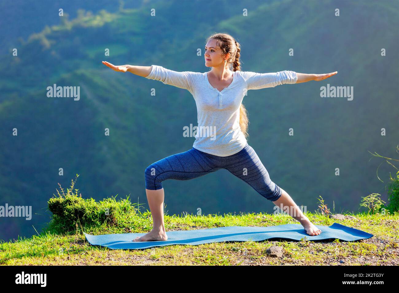 Woman doing yoga asana Virabhadrasana 2 - Warrior pose outdoors Stock ...