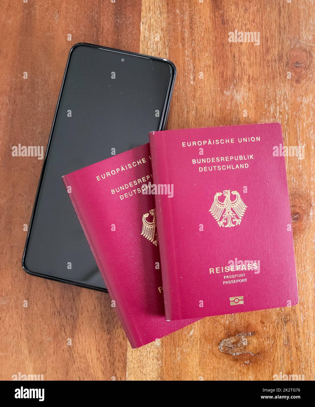 Two German passports and a smartphone on a wooden background for ...