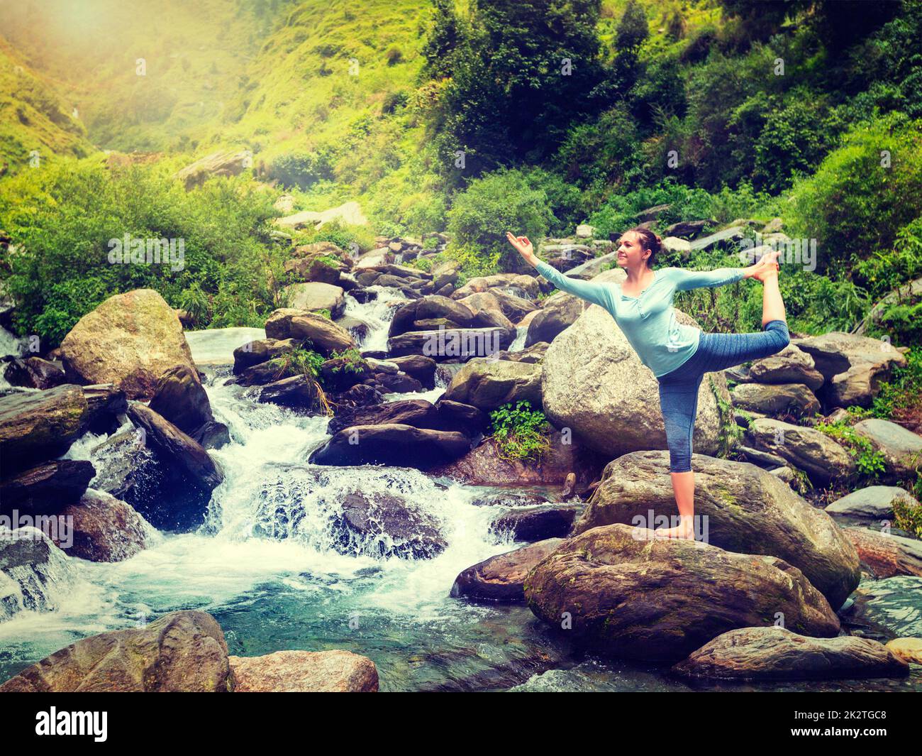 Woman doing yoga asana Natarajasana outdoors at waterfall Stock Photo ...