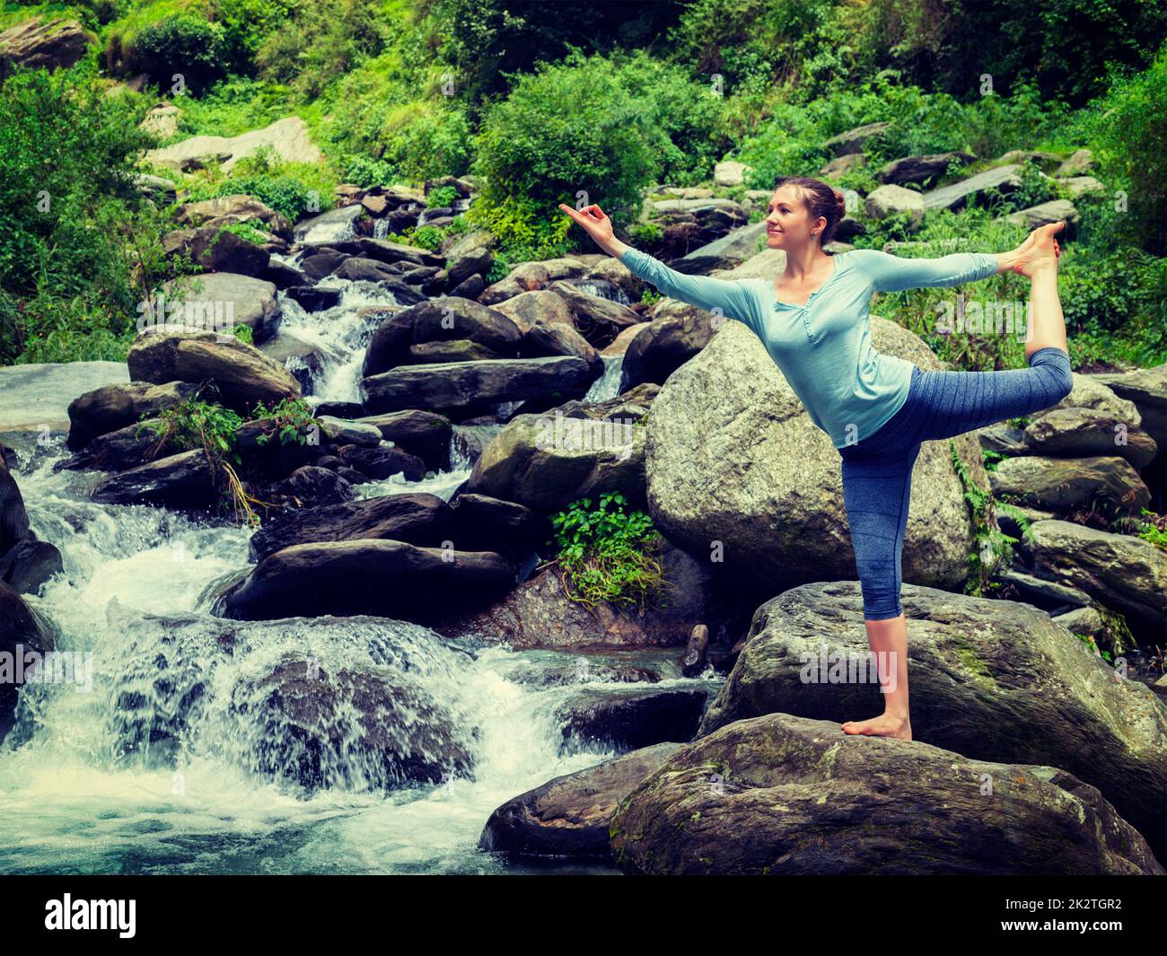 Woman doing yoga asana Natarajasana outdoors at waterfall Stock Photo ...