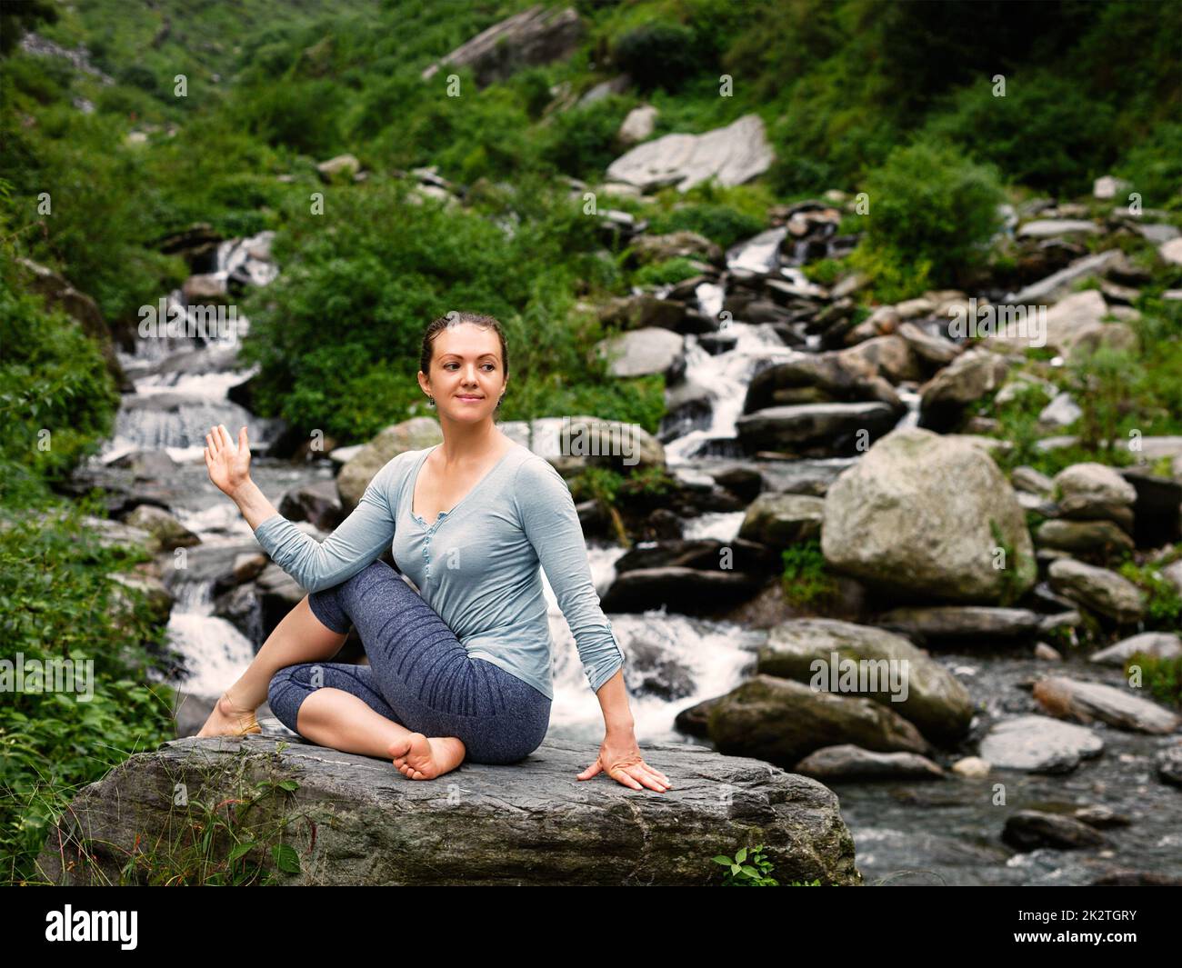 Woman doing Ardha matsyendrasana asana outdoors Stock Photo - Alamy