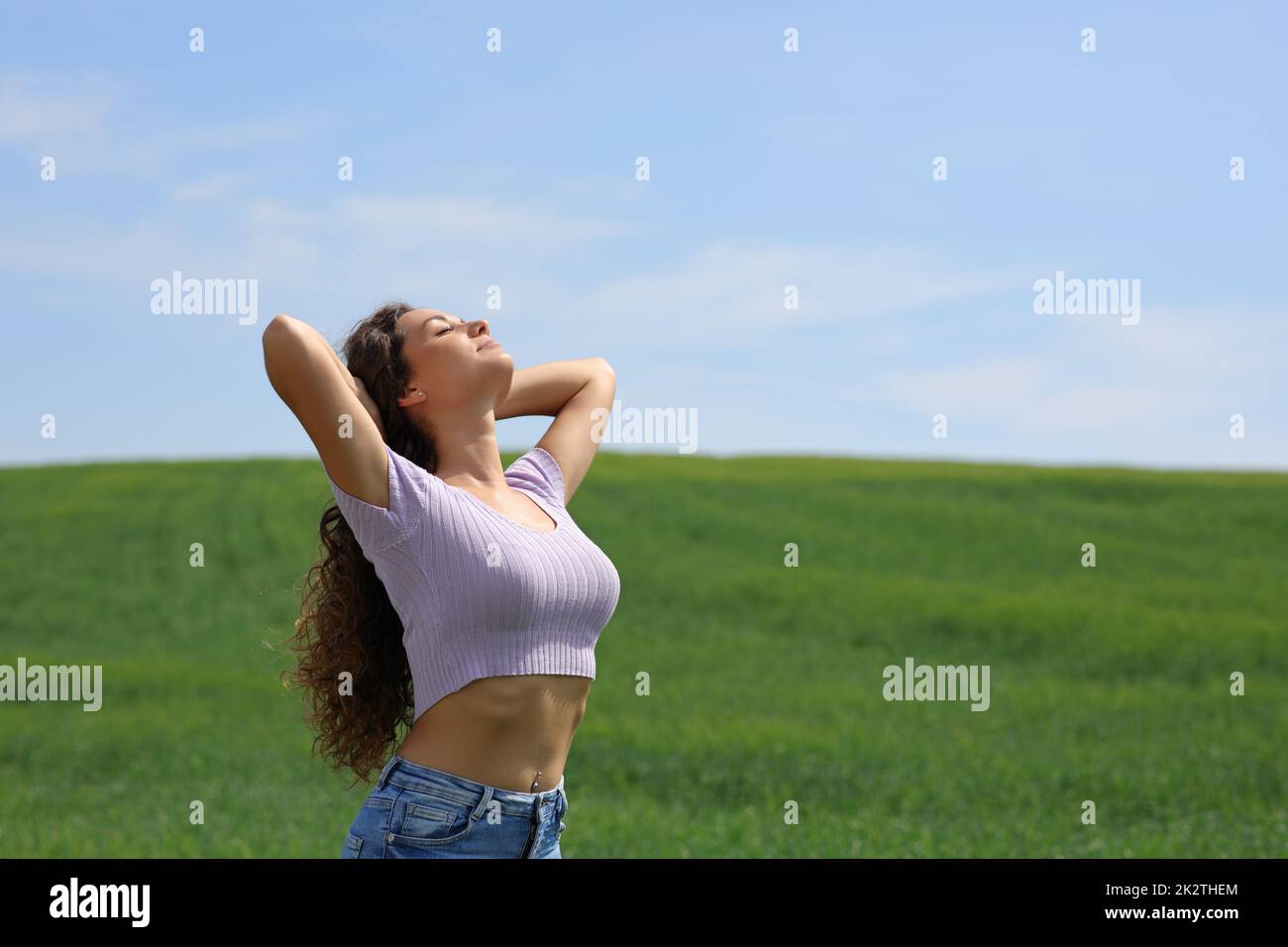 Woman relaxing with arms on head breathing in a field Stock Photo - Alamy