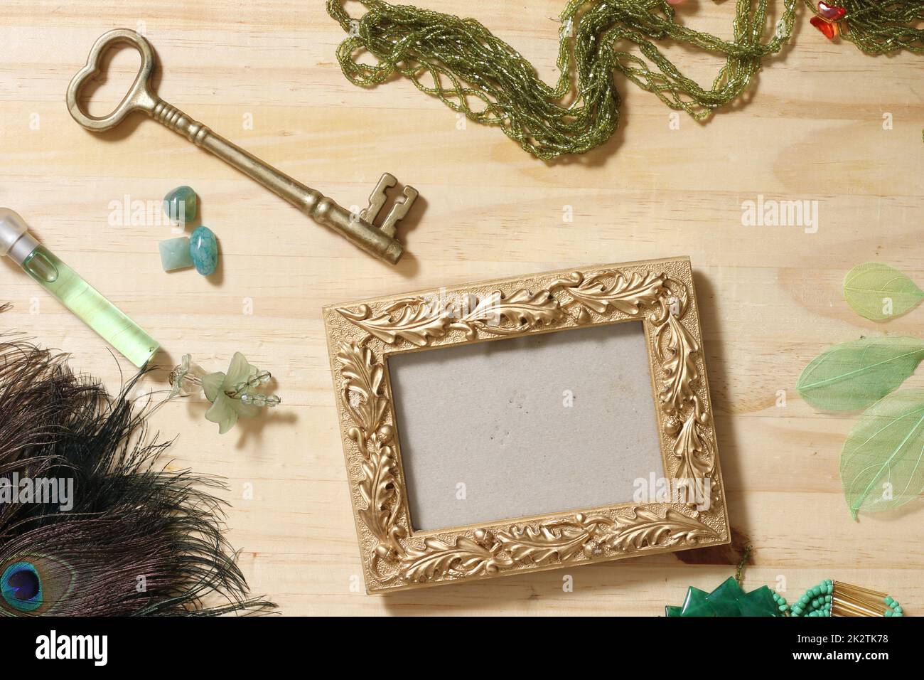 Green Jewelry and Peacock Feathers With Gold Picture Frame on Wooden ...