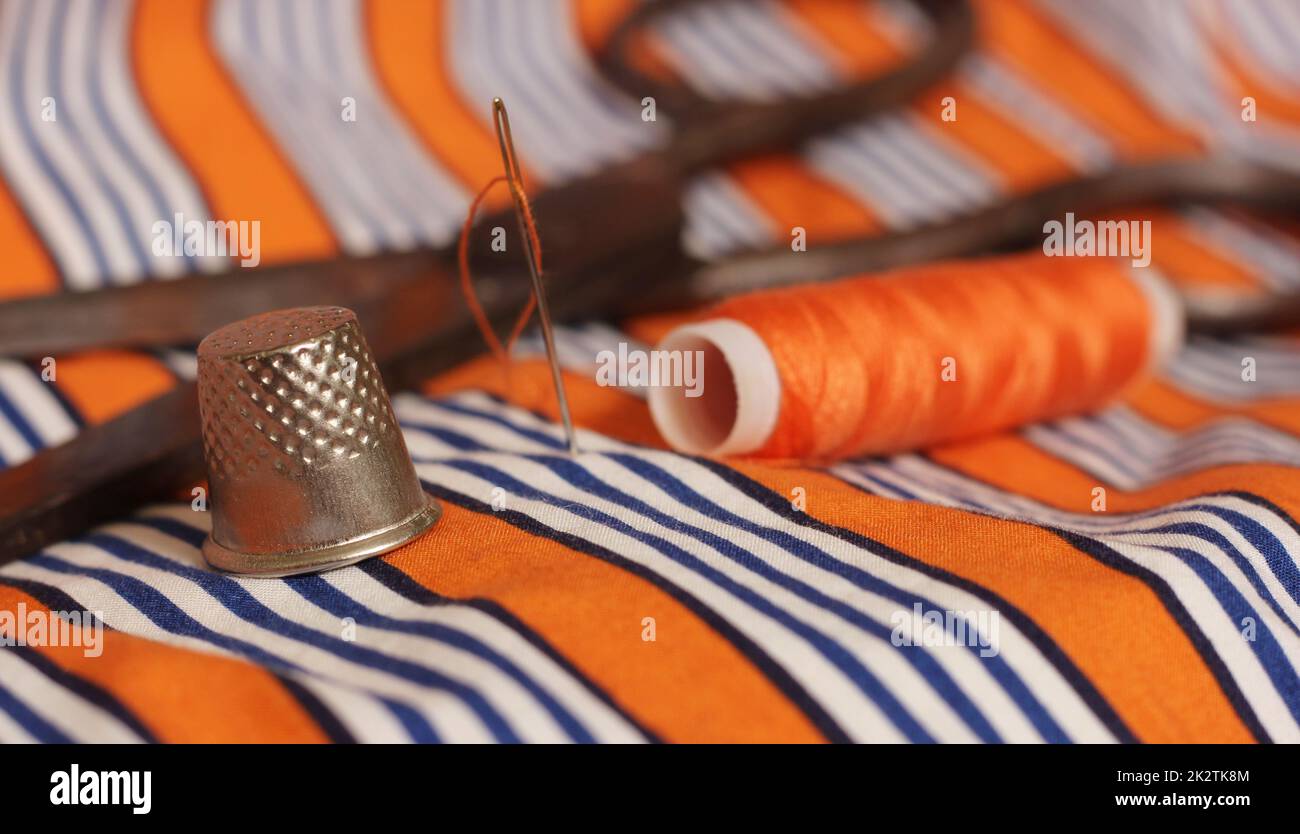 Orange Thread and Thimble on Orange and White Striped Fabric Stock ...