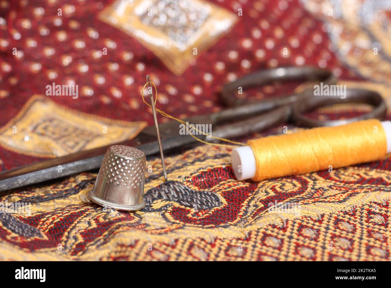 Golden Thread and Thimble on Vintage Fabric From The Middle East Stock ...