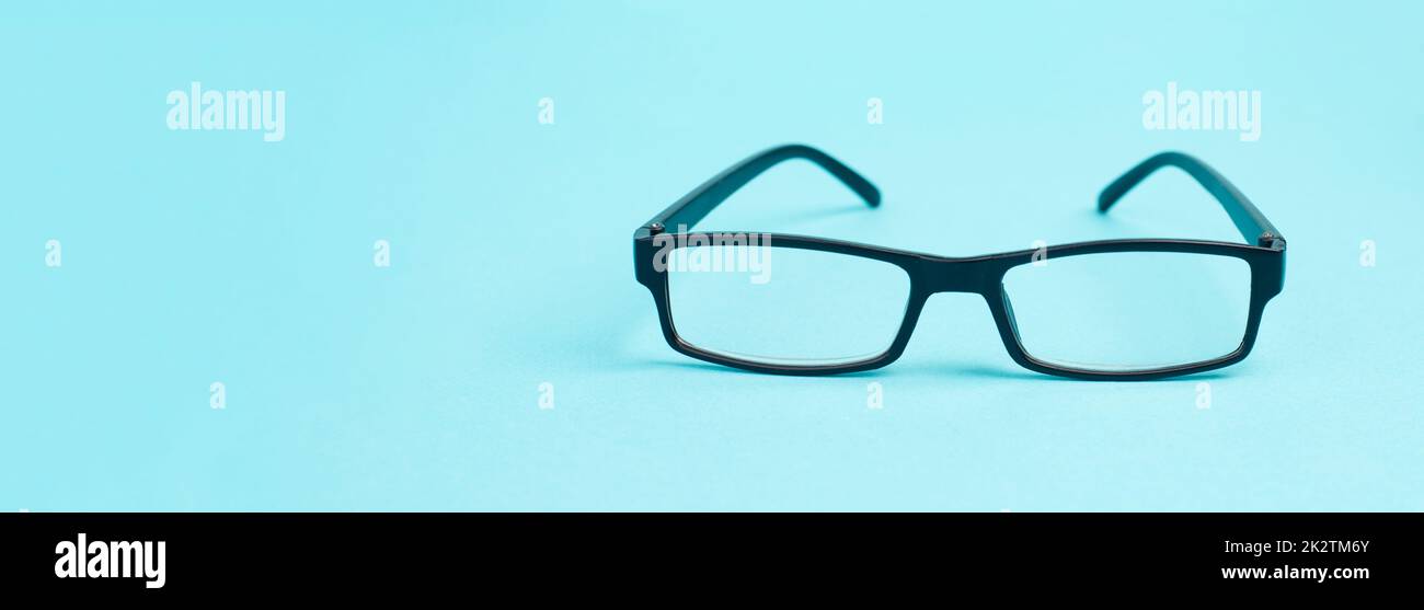 Glasses with a black frame on a blue background, copy space for text ...