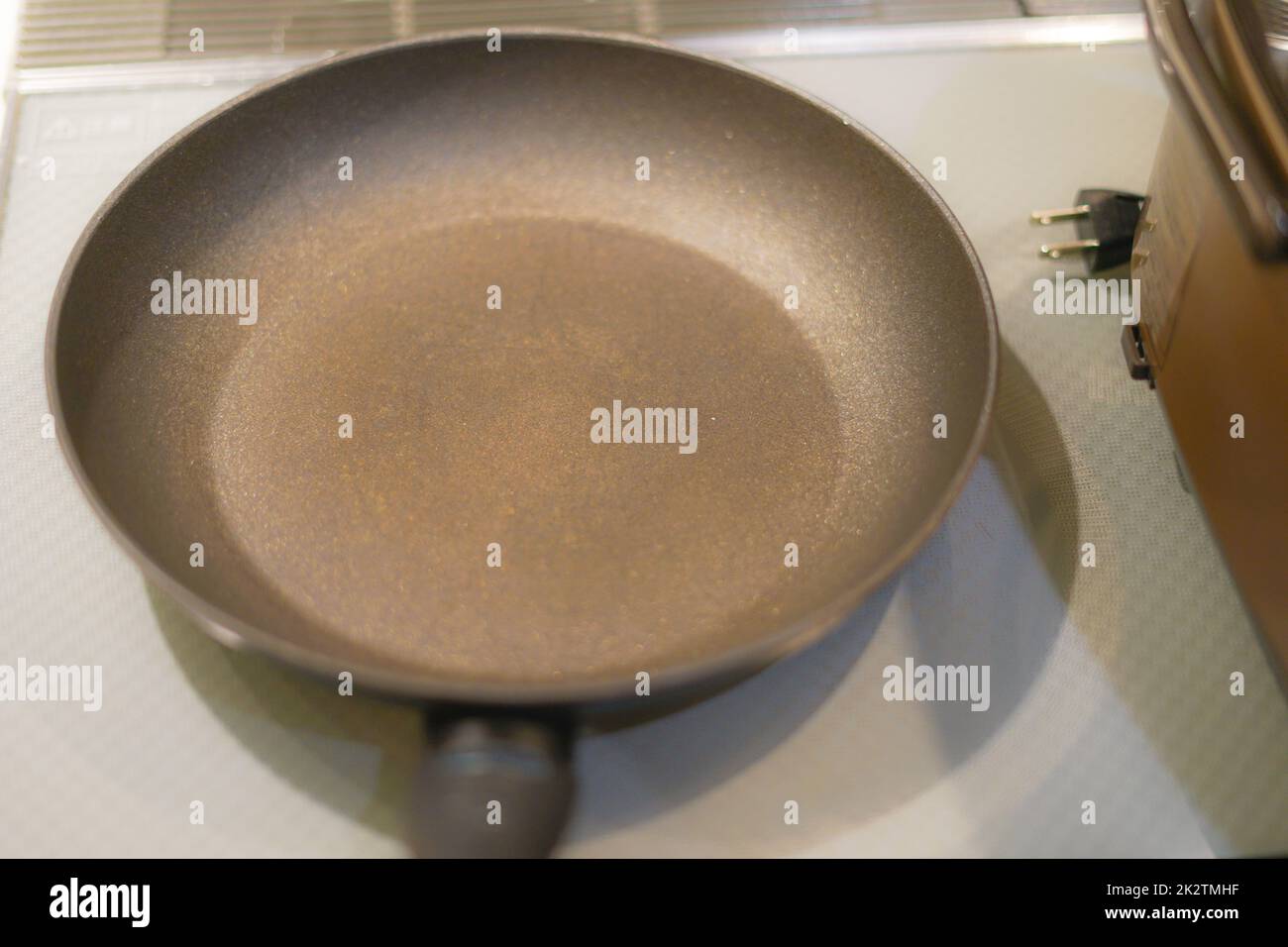 Metal frying pan placed in IH Stock Photo - Alamy