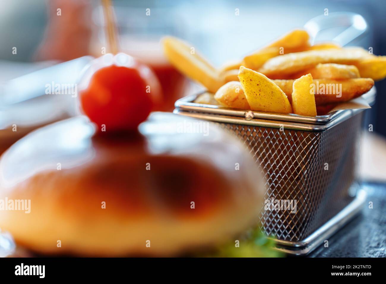 Focus in the background on french fries in a mesh basket standing near ...
