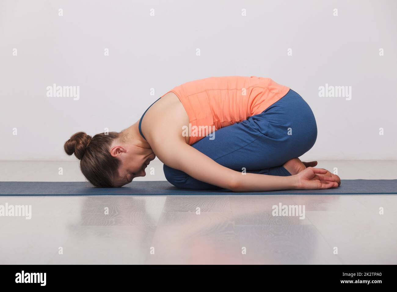 Beautiful sporty fit yogini woman practices yoga asana balasana (child ... Beautiful sporty fit yogini woman practices yoga asana balasana (child ...