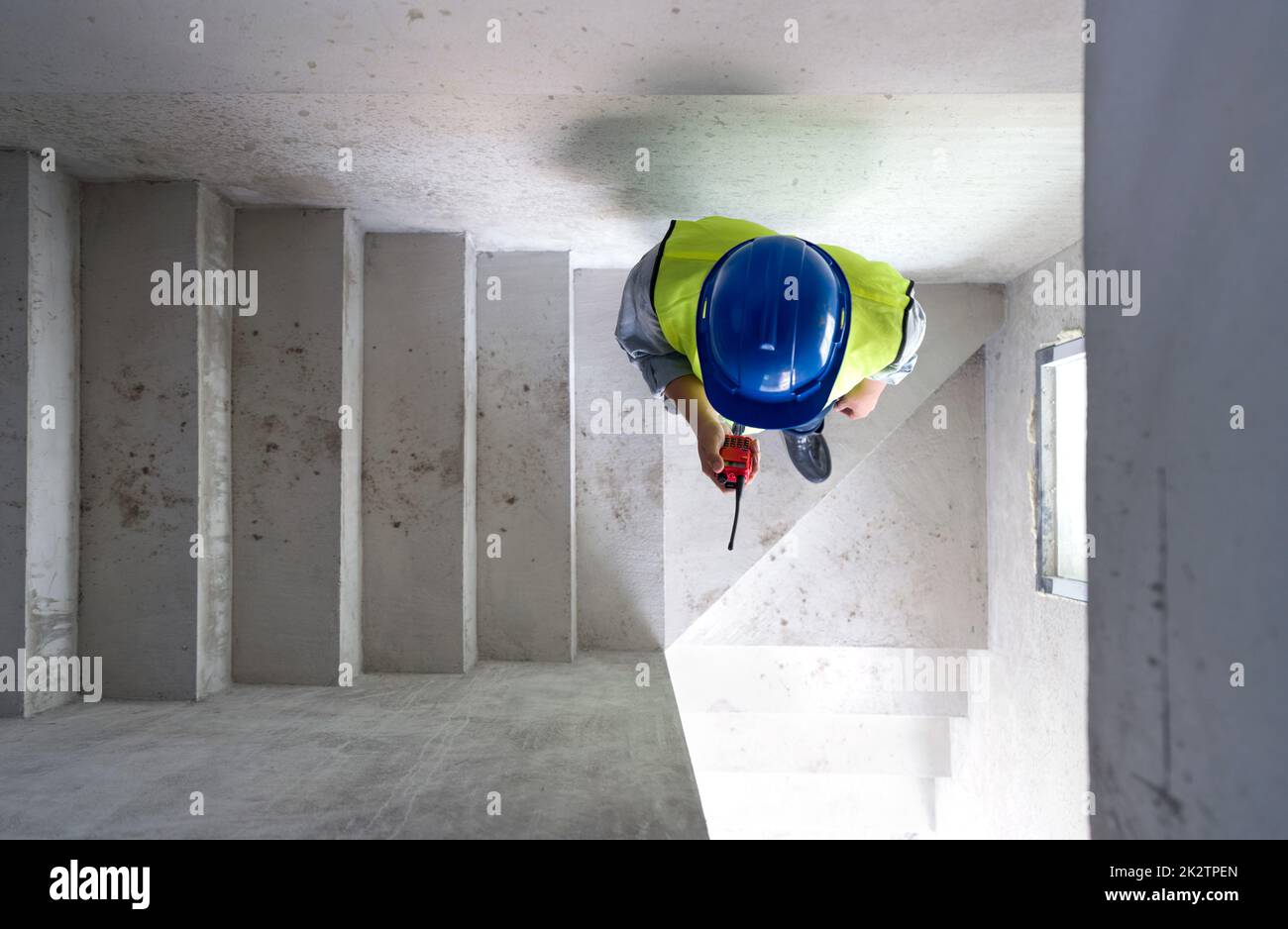Engineer in hardhat, safety vest and Walkie-Talkie checking house ...