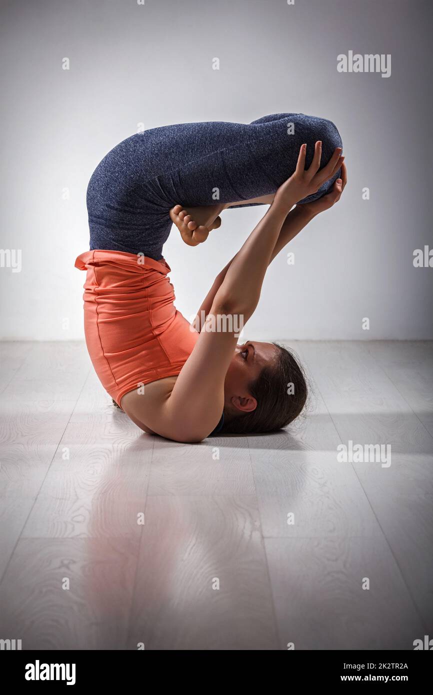 Sporty fit woman practices inverted yoga asana Stock Photo - Alamy