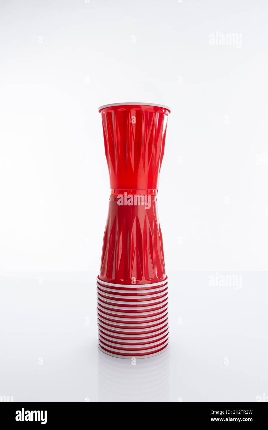 A vertical of a red disposable plastic cup put on a horizontal stack of ...