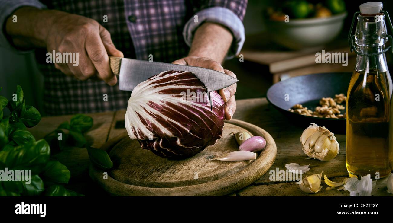 Crop man halving red cabbage for lunch Stock Photo - Alamy