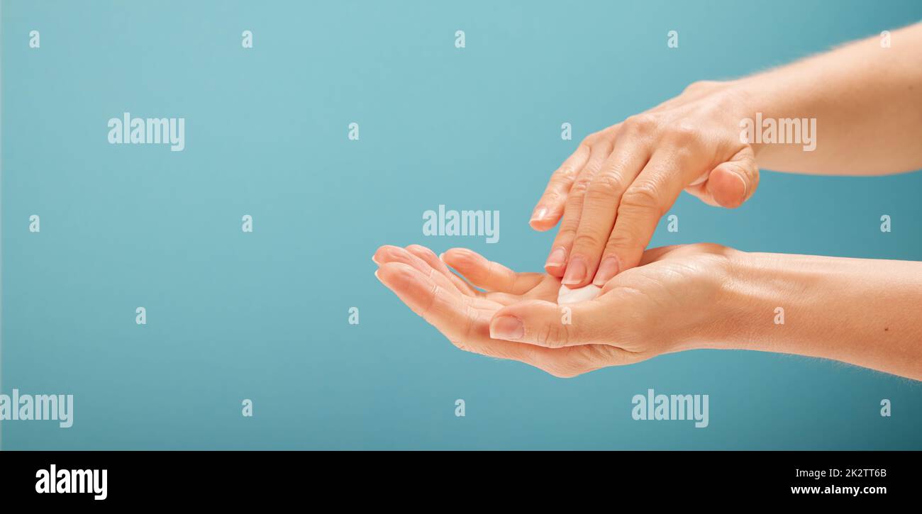 Anonymous woman taking cream from hand Stock Photo - Alamy