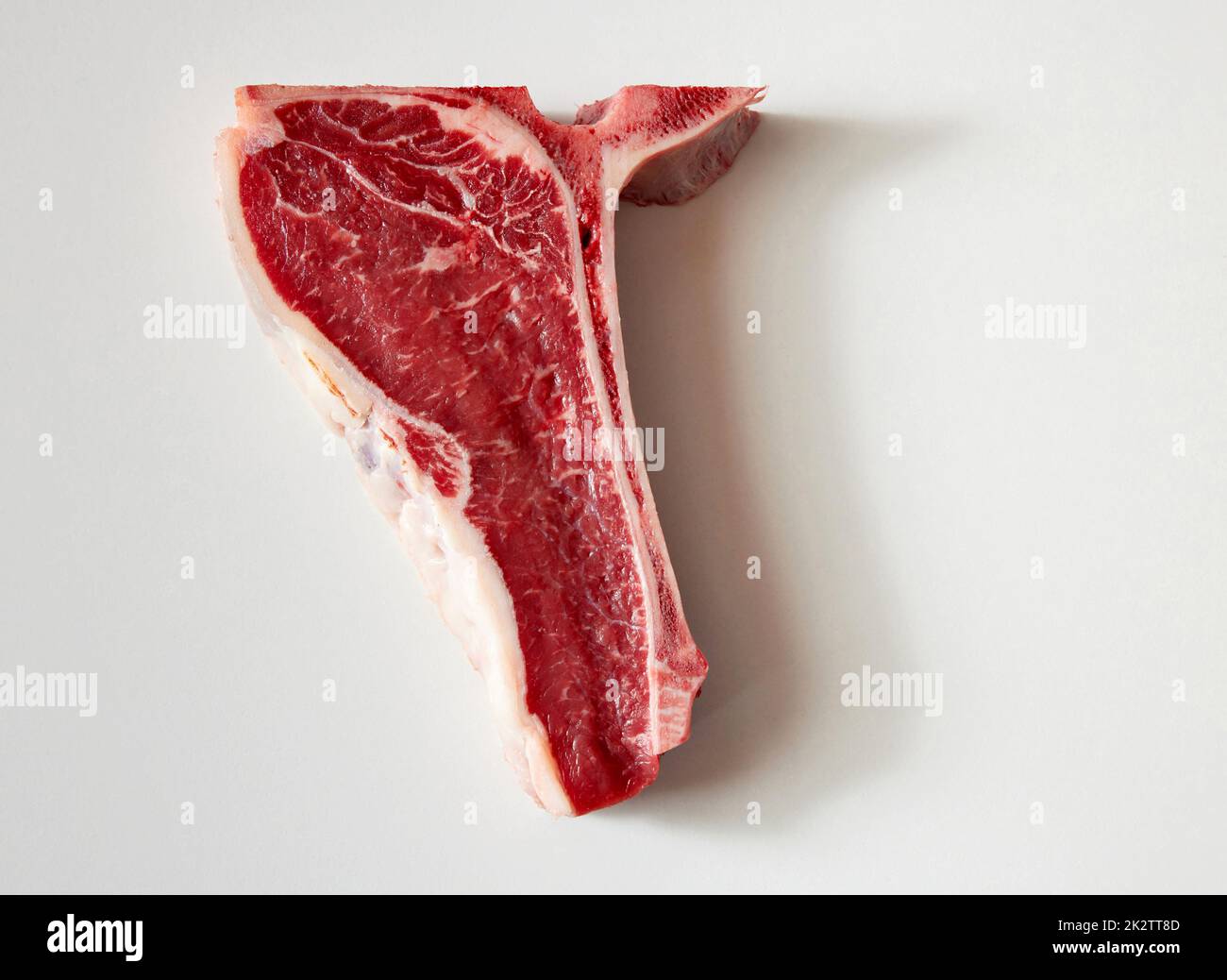 Half porterhouse or t bone steak on white background Stock Photo - Alamy