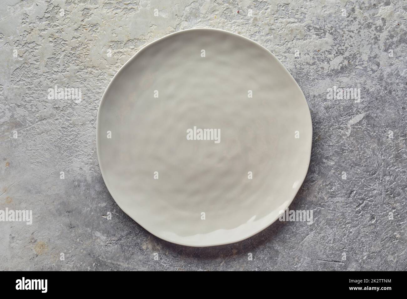 Round ceramic plate on plaster surface Stock Photo - Alamy