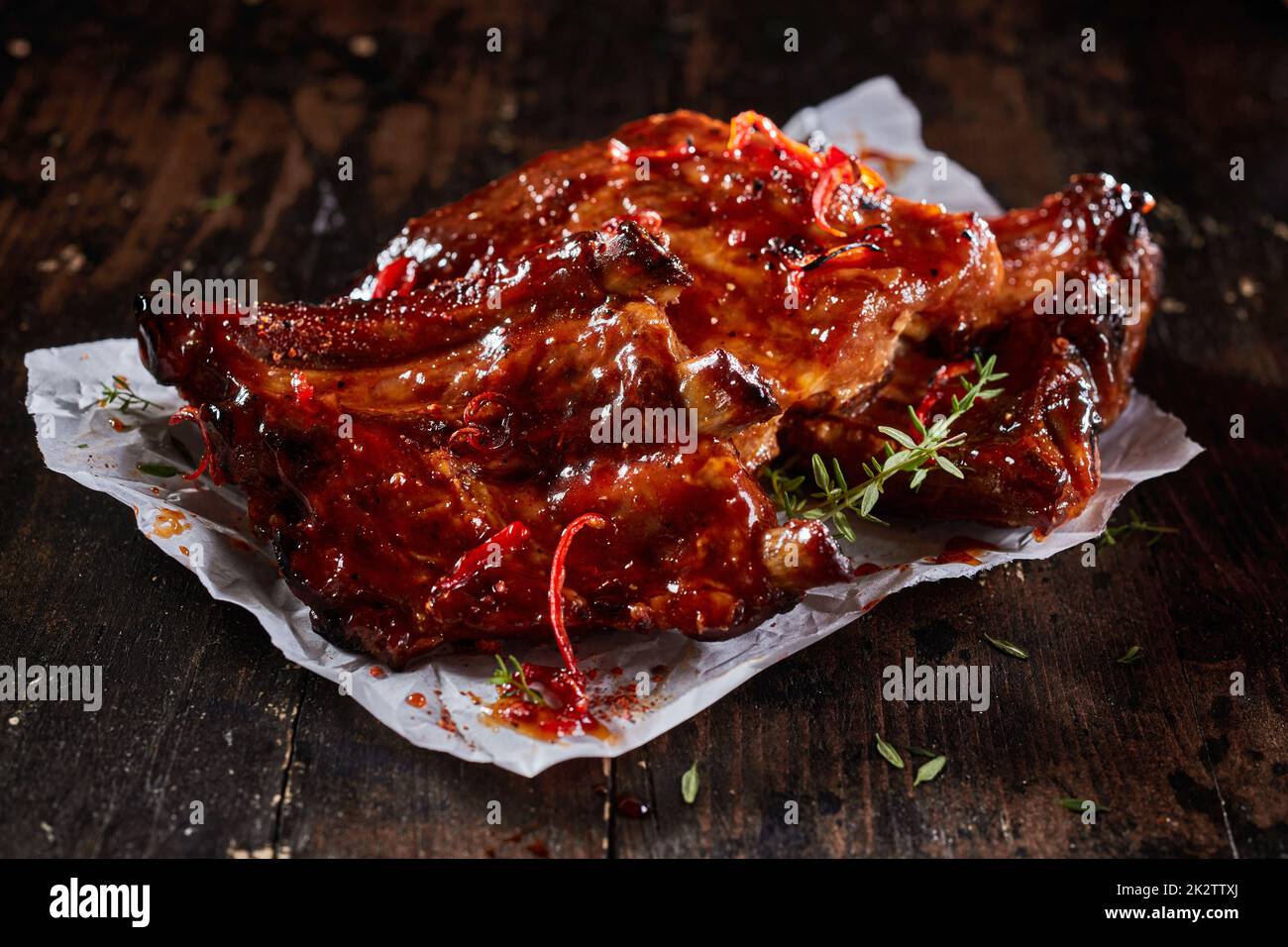 Tasty roasted ribs under spicy sauce placed on table Stock Photo - Alamy