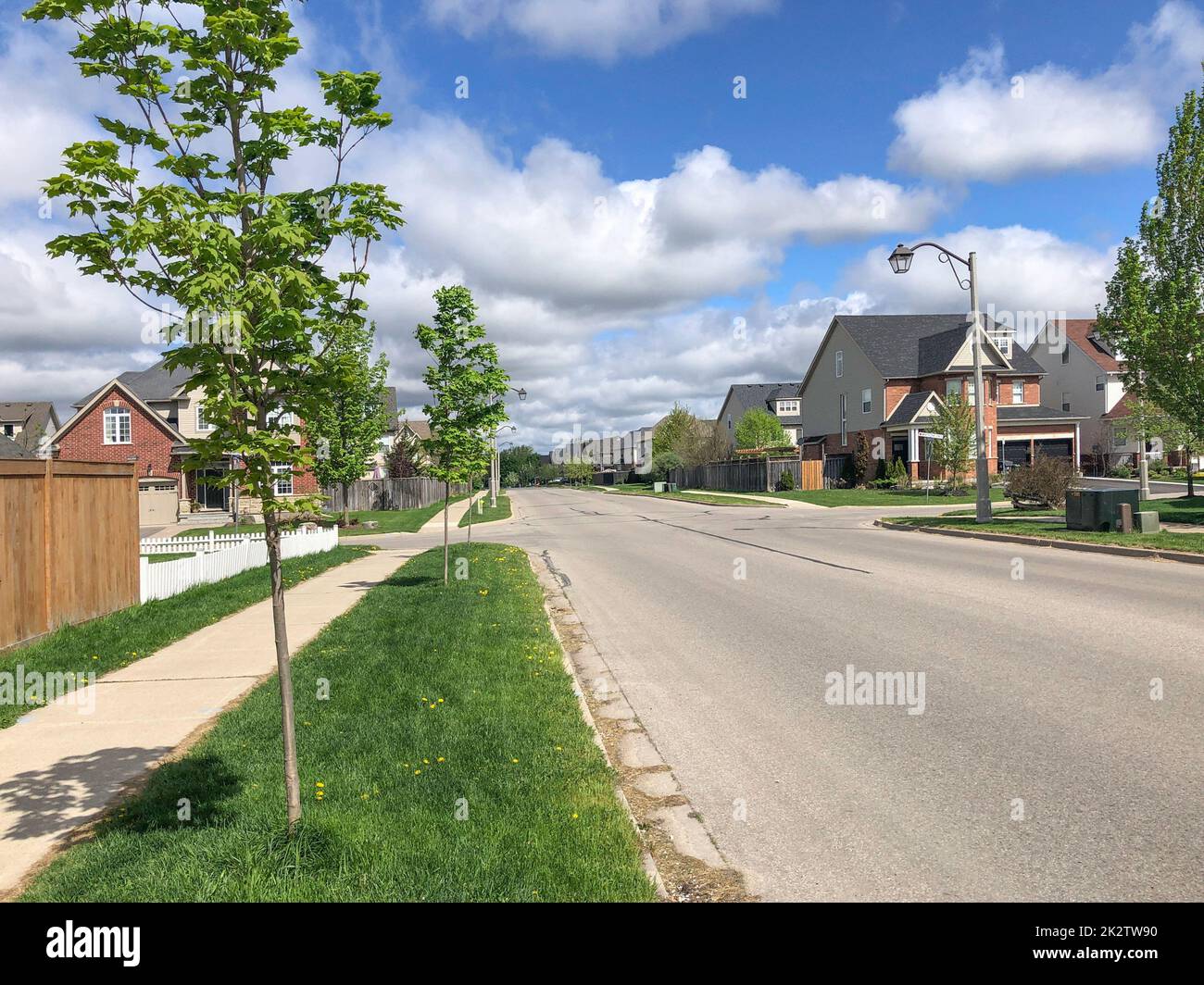 Spring city street under blue sky with white clouds Stock Photo - Alamy