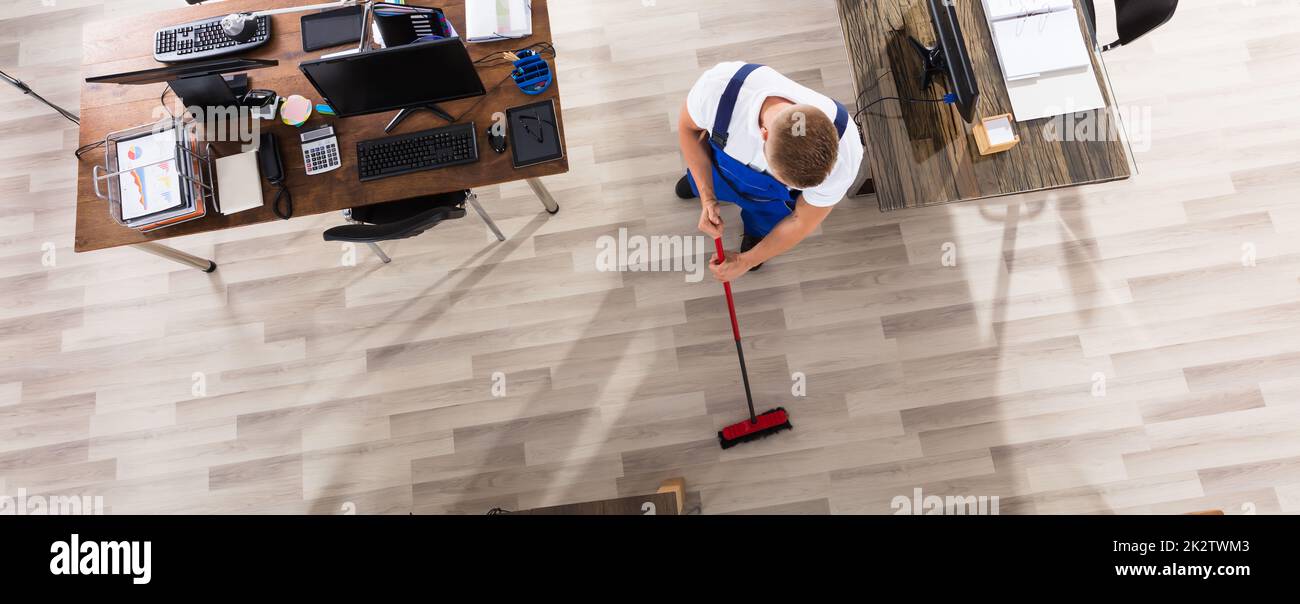 Janitor Cleaning Floor With Broom In Office Stock Photo - Alamy