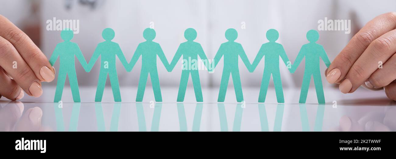 Doctor's Hand Holding Chain Of Human Figure Holding Hand Stock Photo ...