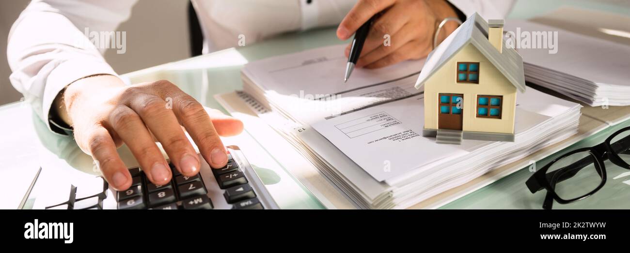 Businessman's hand calculating invoice Stock Photo - Alamy