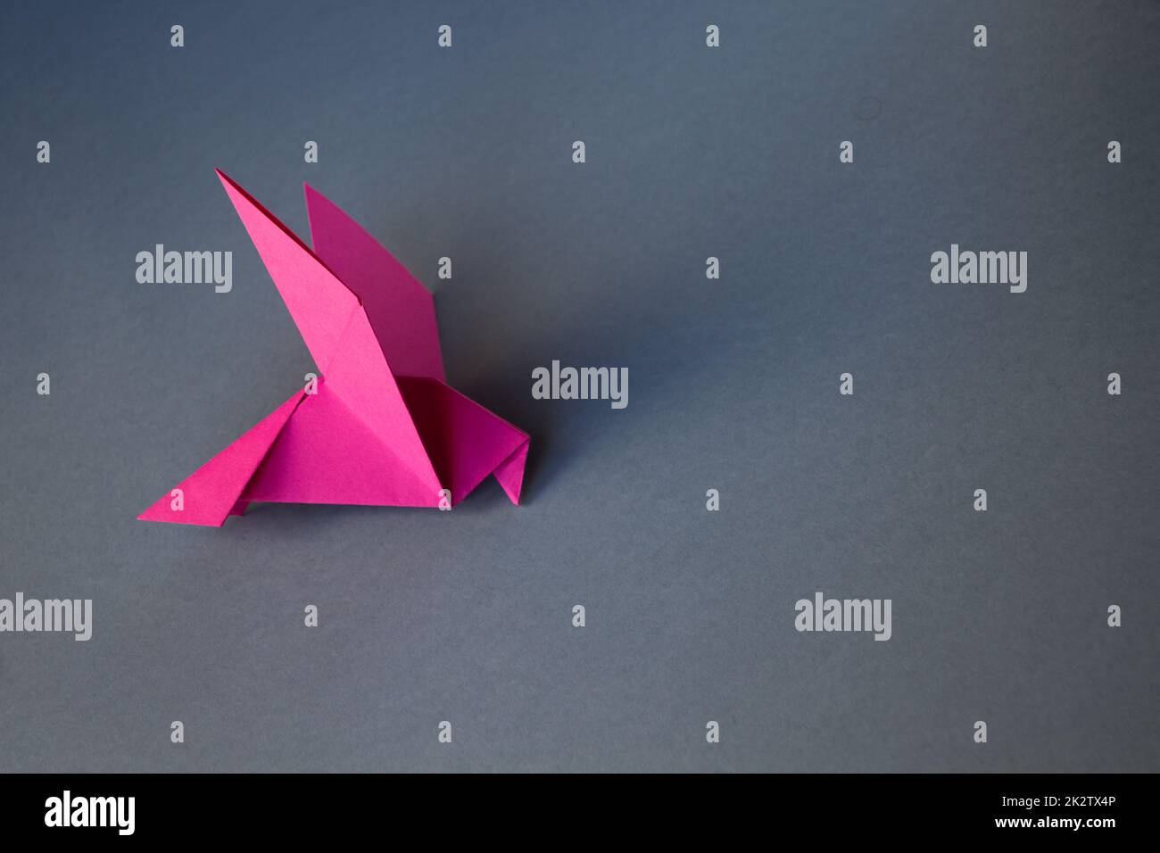 Pink paper dove origami isolated on a grey background Stock Photo - Alamy