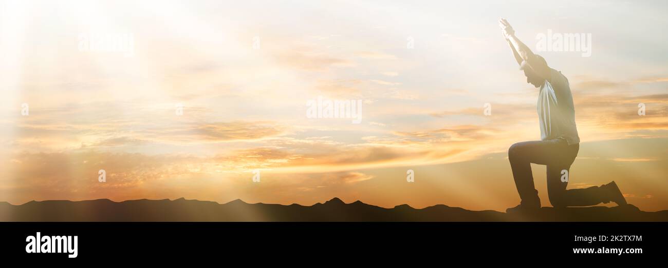 Man Kneeling And Praying At Sunset Stock Photo - Alamy