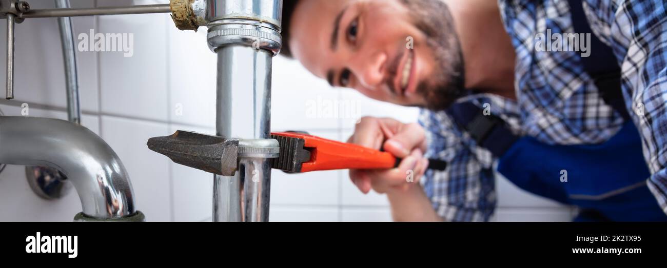 Plumber Repairing Sink In Bathroom Stock Photo - Alamy