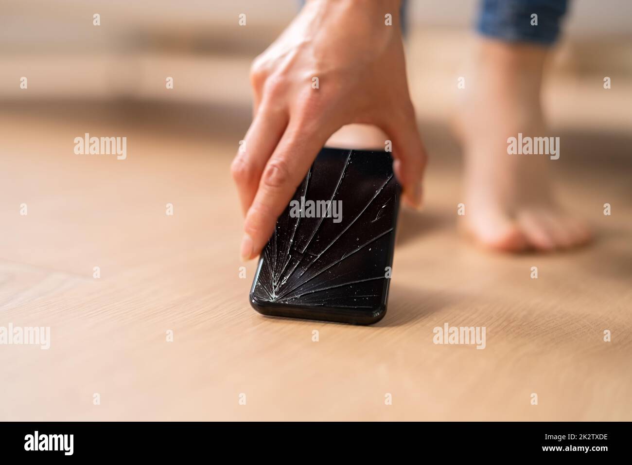 Woman Picking Up Damaged Mobile Phone Stock Photo - Alamy